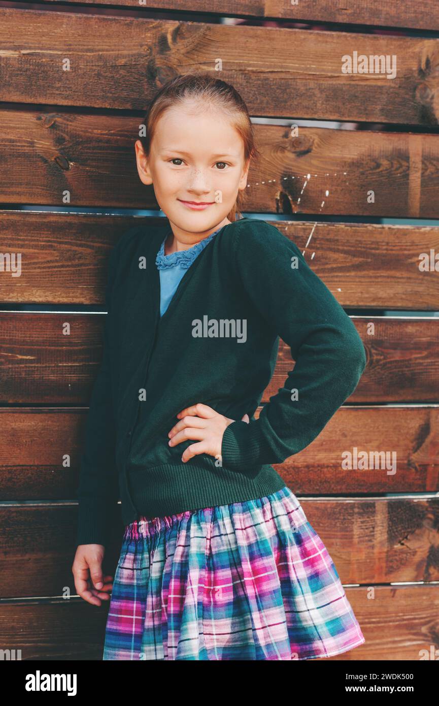 Outdoor portrait of pretty little 7-8 year old schoolgirl wearing ...