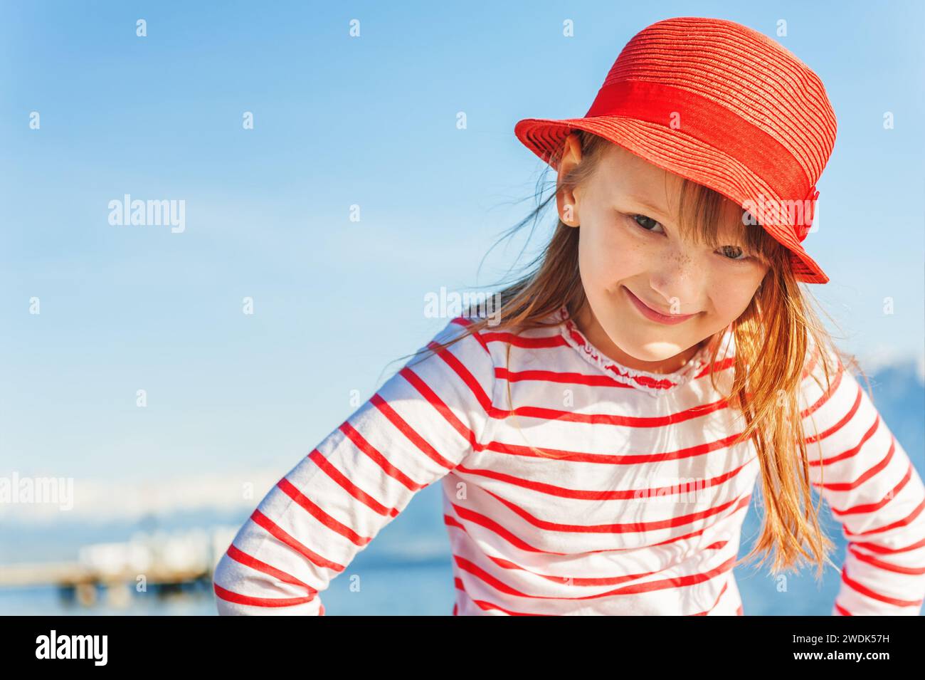 Outdoor portrait of adorable little kid girl against sunny blue sky ...