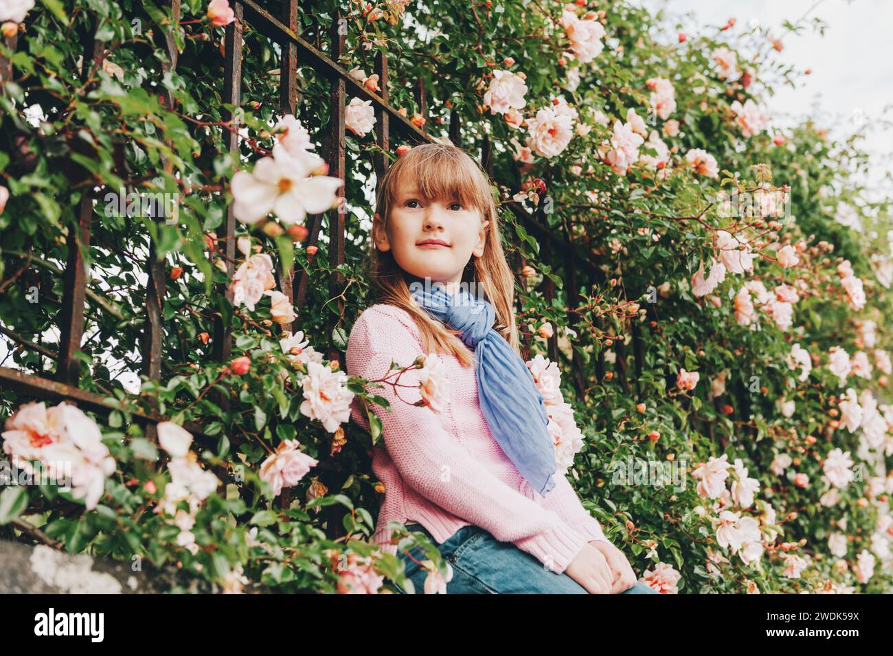 Outdoor portrait of pretty little 7 year old girl wearing pink pullover ...