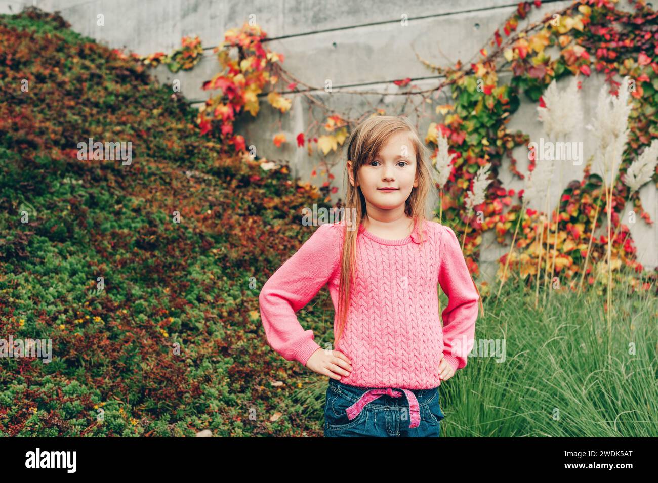 Outdoor portrait of pretty little 7 year old girl wearing pink pullover ...