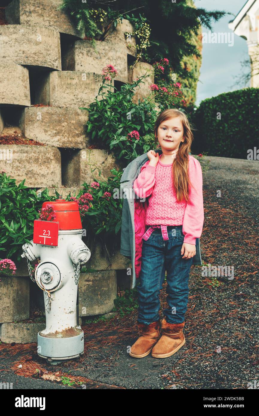 Outdoor portrait of pretty little 7 year old girl wearing pink pullover ...