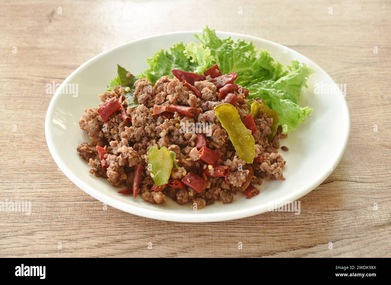 spicy fried chop beef meat couple dry chili with lettuce on plate Stock ...