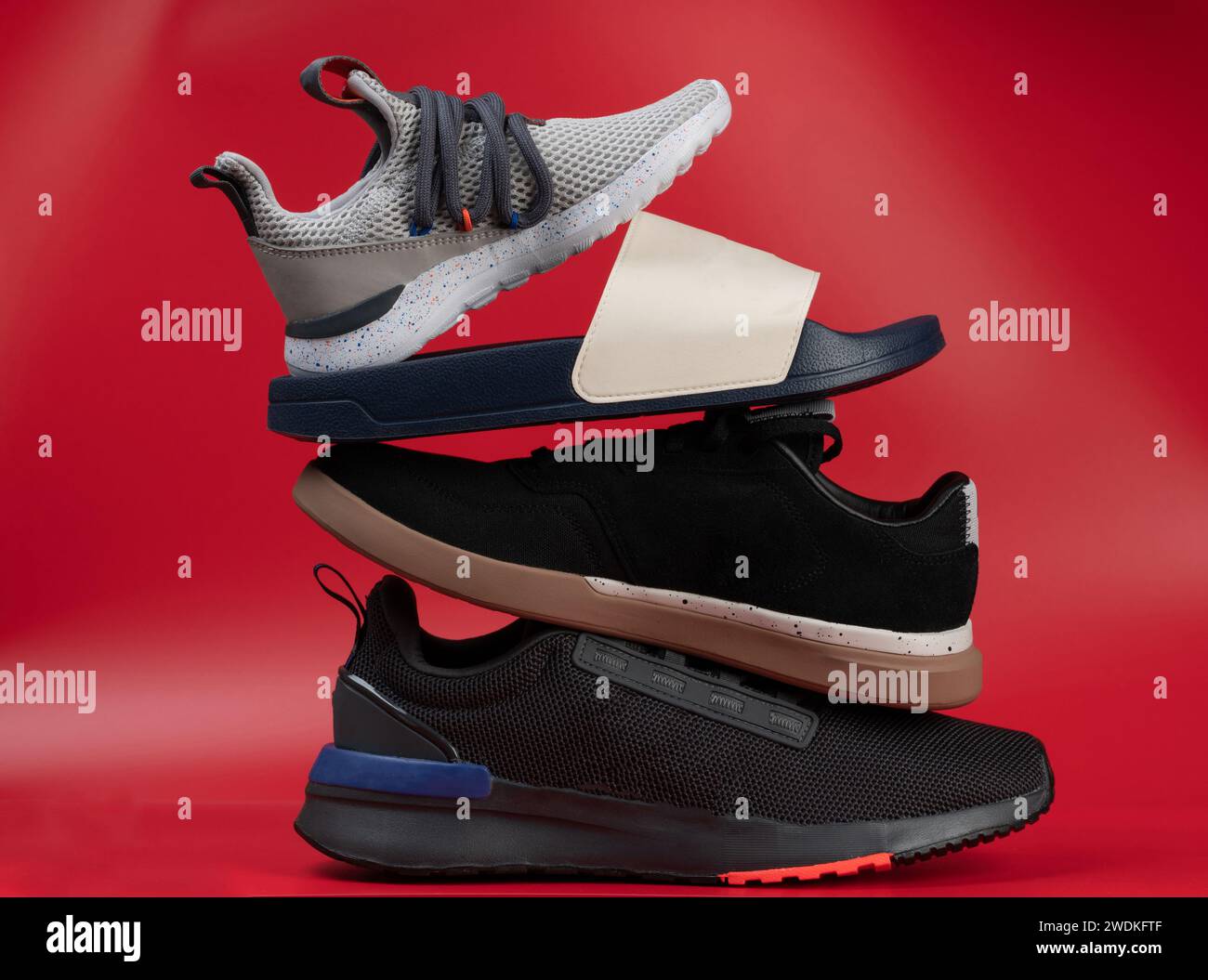 Stack of diffrent shoes isolated on red studio background Stock Photo ...