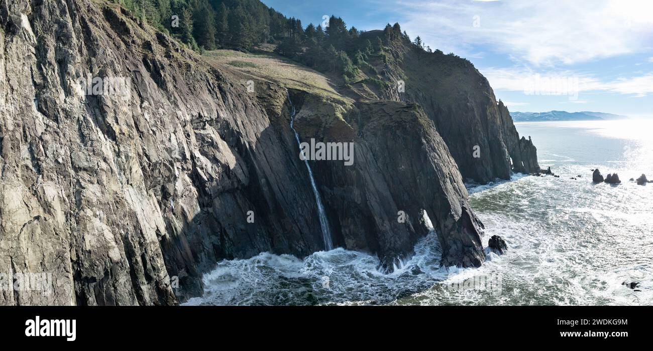 A narrow waterfall tumbles off an impressive cliff near the Neahkahnie ...