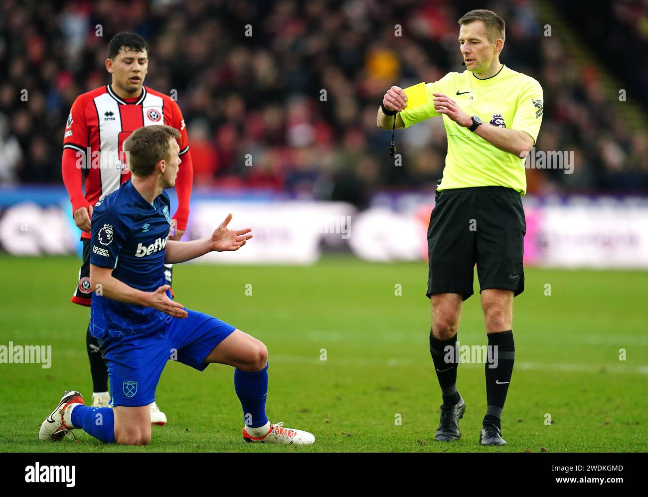 Referee Michael Salisbury (right) shows a yellow card to West Ham ...