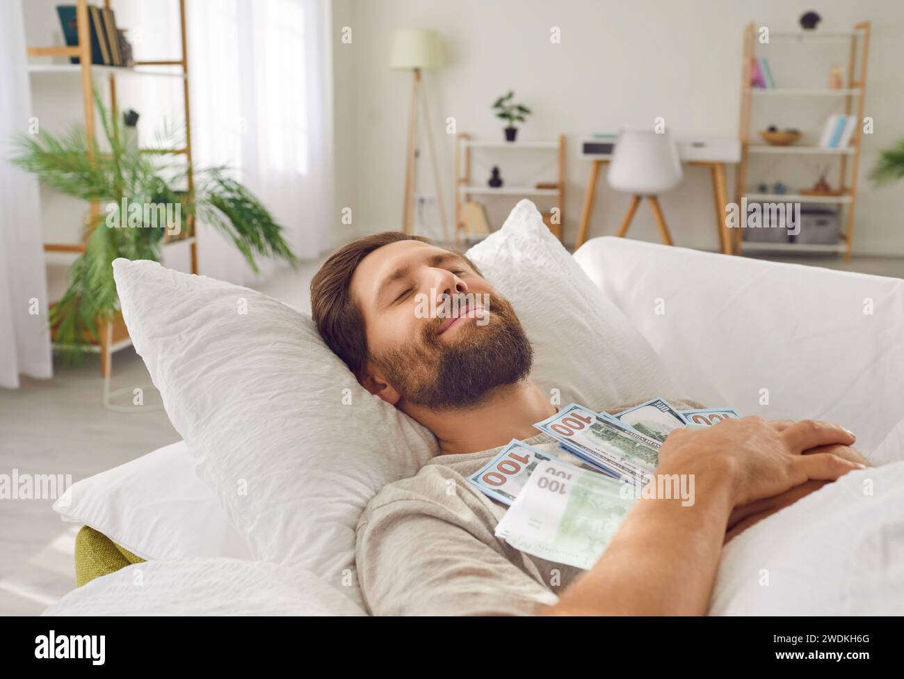Smiling sleeping man lying in bed with closed eyes, embracing lots of ...