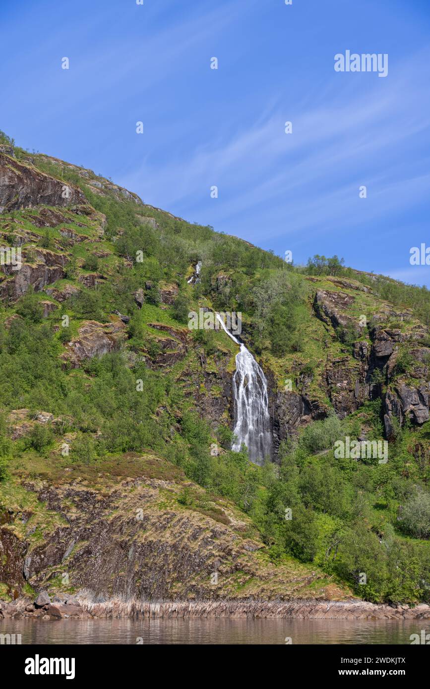 Vertical view of a cascading waterfall in Trollfjorden, Norway, cutting ...