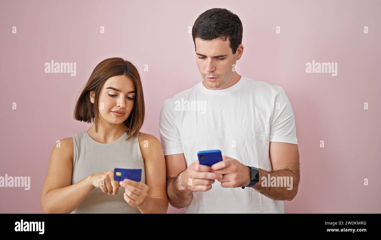Beautiful couple standing together shopping with smartphone and credit ...