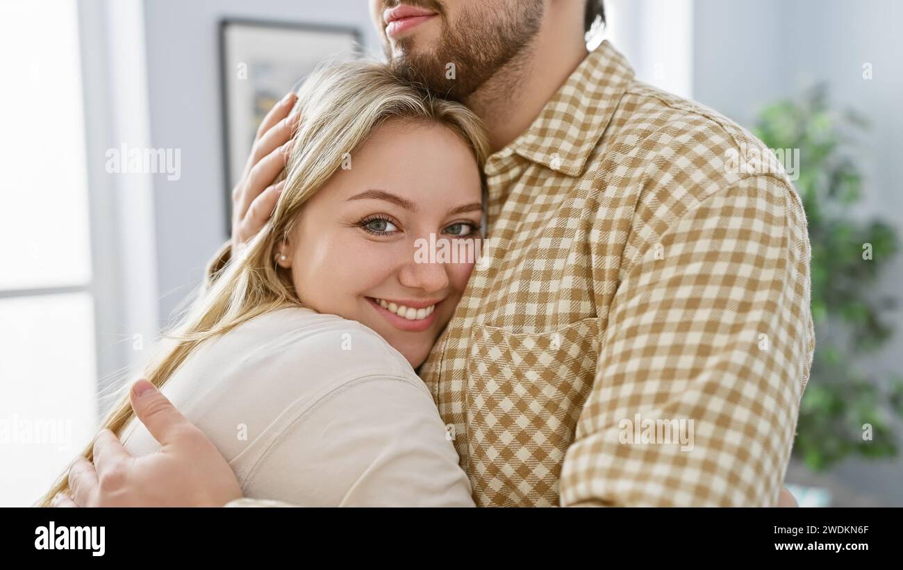 A loving couple embraces warmly in their cozy living room, showcasing ...