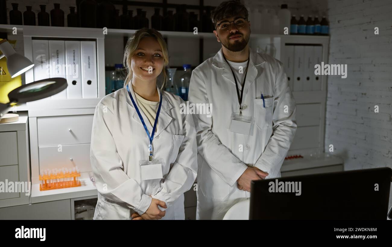 Man and woman in white lab coats are coworkers in a laboratory with ...