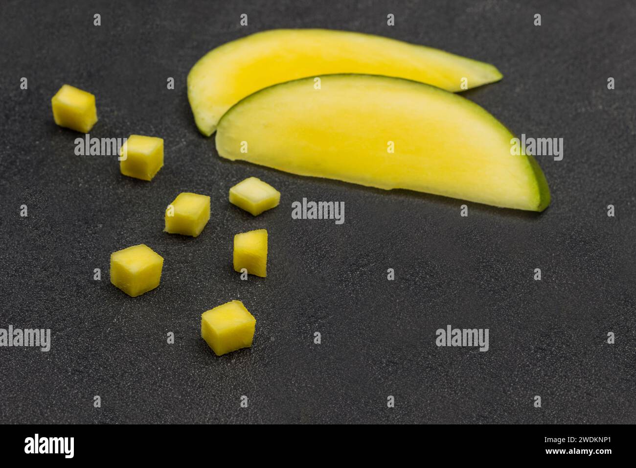 Sliced mango wedges on black background. Diet food concept. Top view ...