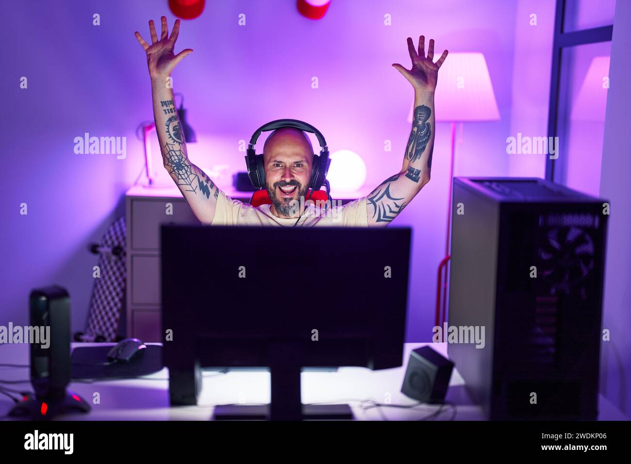 Young bald man streamer playing video game with winner expression at ...