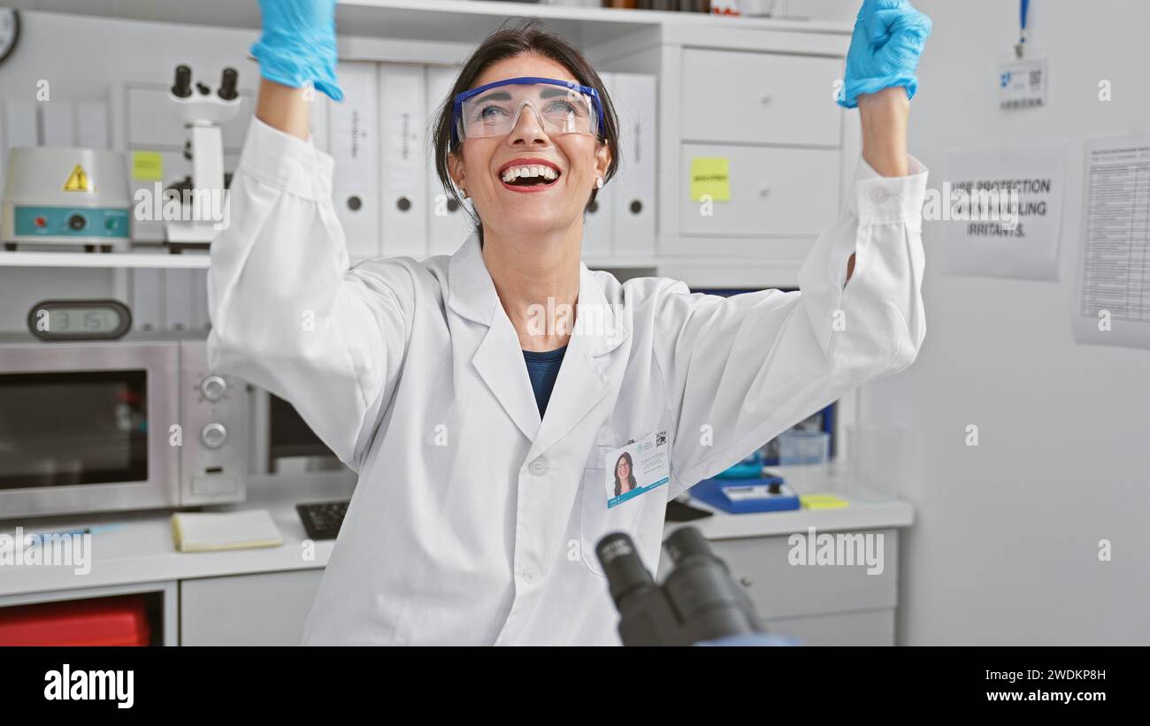 A cheerful mature woman scientist celebrating a breakthrough in a ...