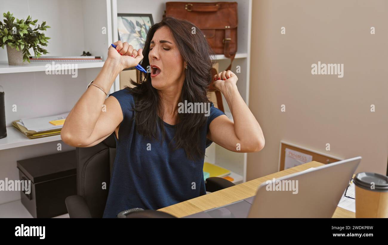 A frustrated mature woman singing in an office setting, showcasing ...