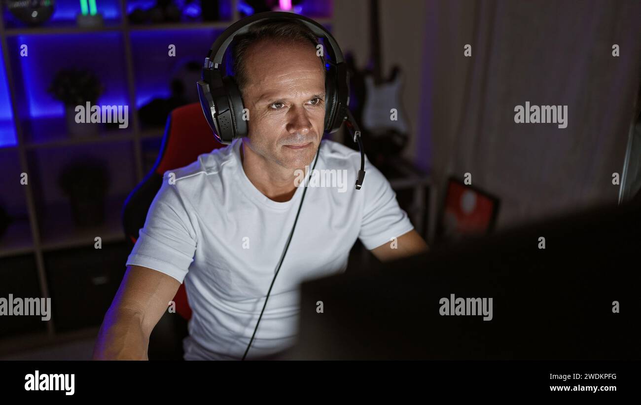 Handsome middle age man streaming video game at night, sitting ...