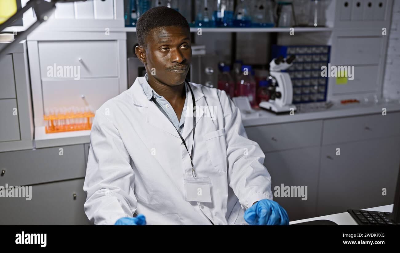 African man scientist in lab coat working in a laboratory with ...