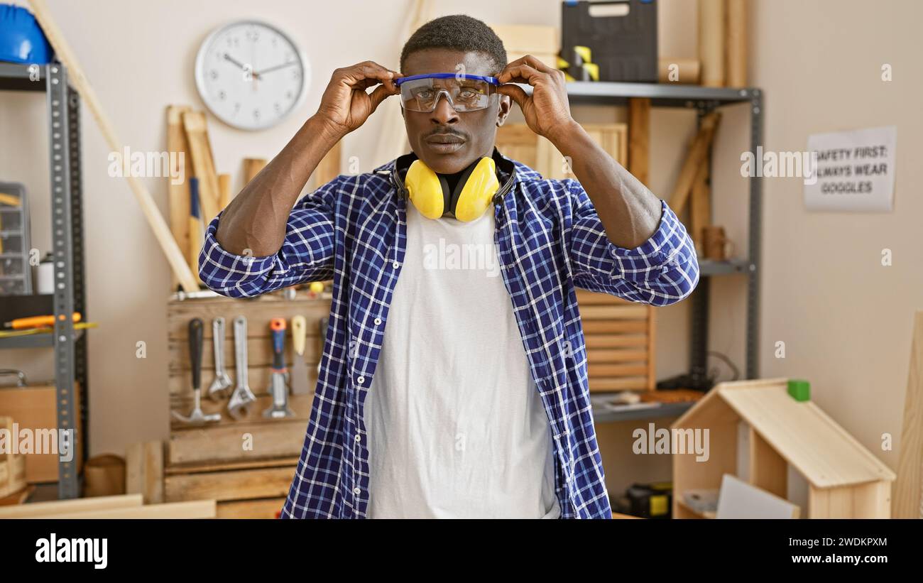 African american man wearing safety goggles in a carpentry workshop ...