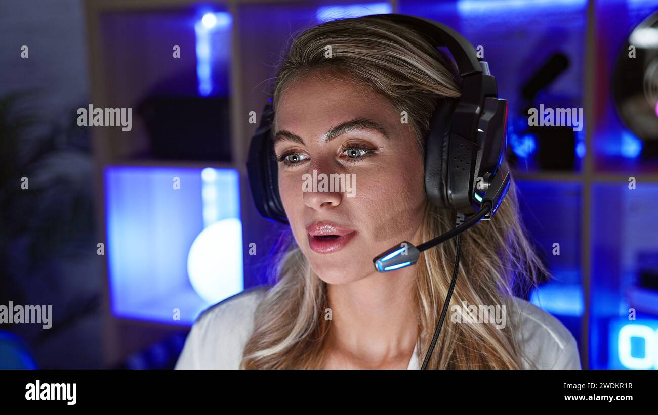 Focused blonde streamer, young woman with serious face gaming ...