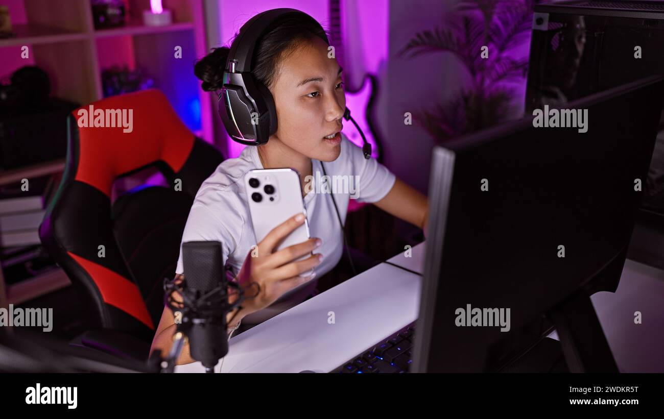 Asian woman wearing headphones multitasking with smartphone and ...