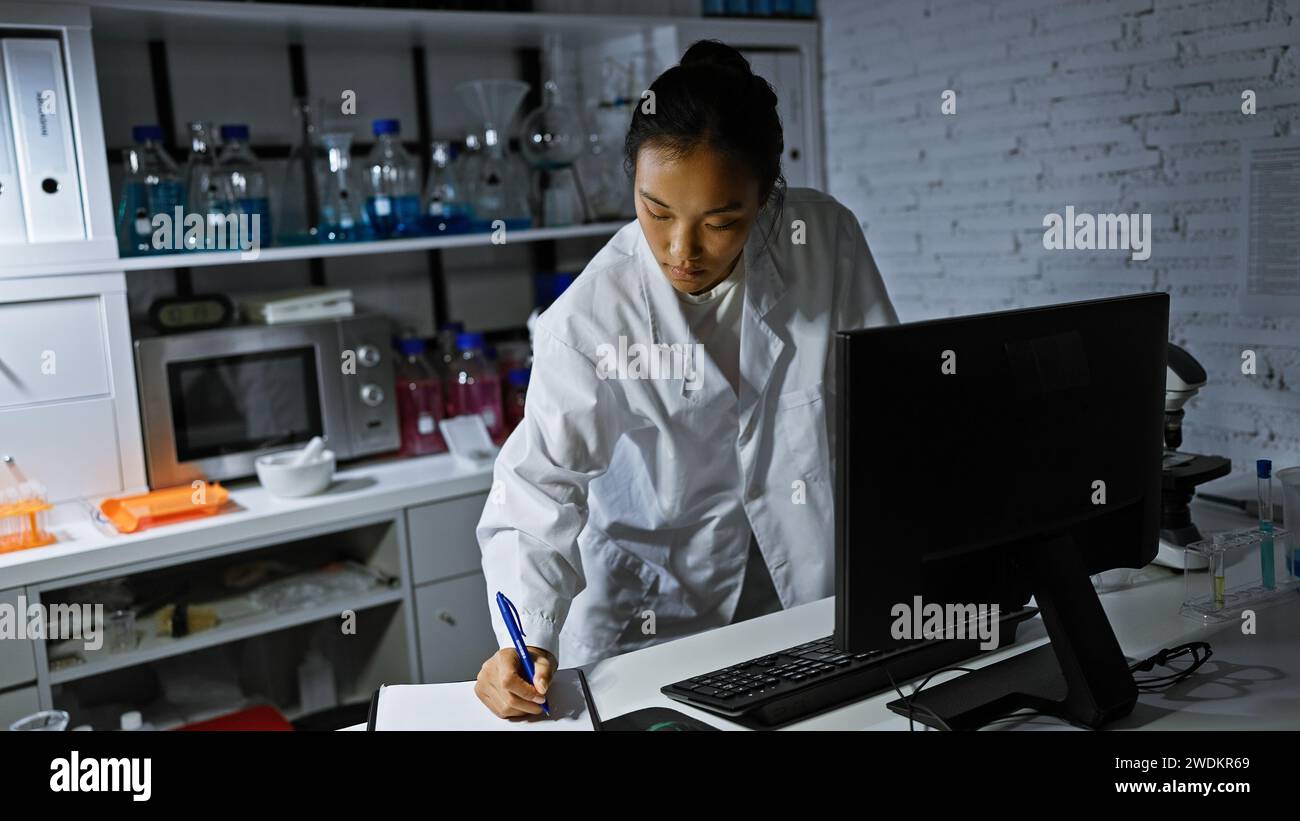 An asian woman scientist takes notes in a modern laboratory setting ...
