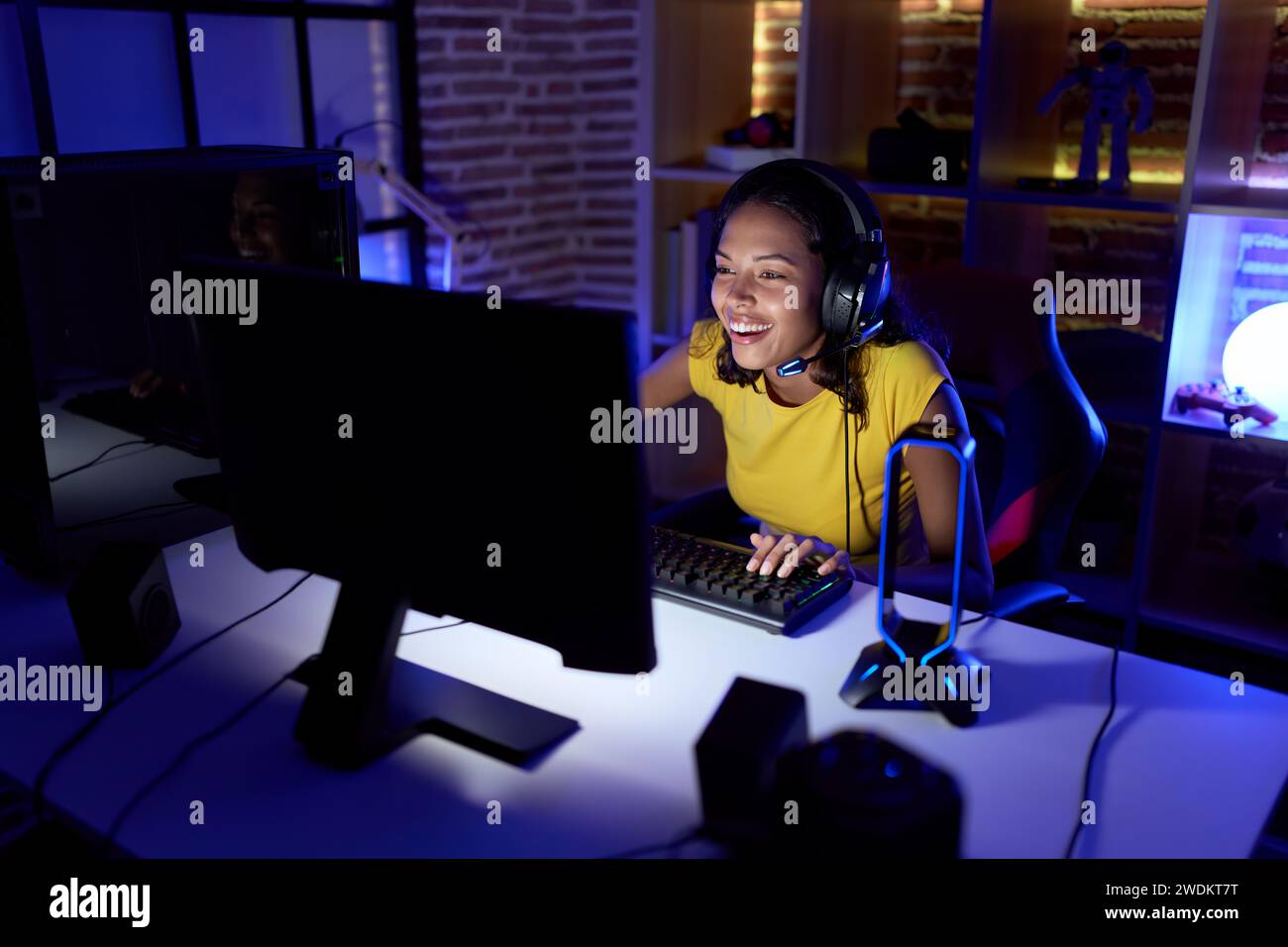 Young african american woman streamer playing video game using computer ...