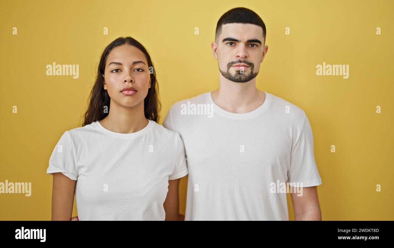 Beautiful couple standing together with serious face over isolated ...
