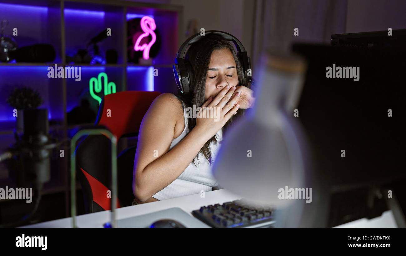 Young beautiful hispanic woman streamer tired using computer at gaming ...