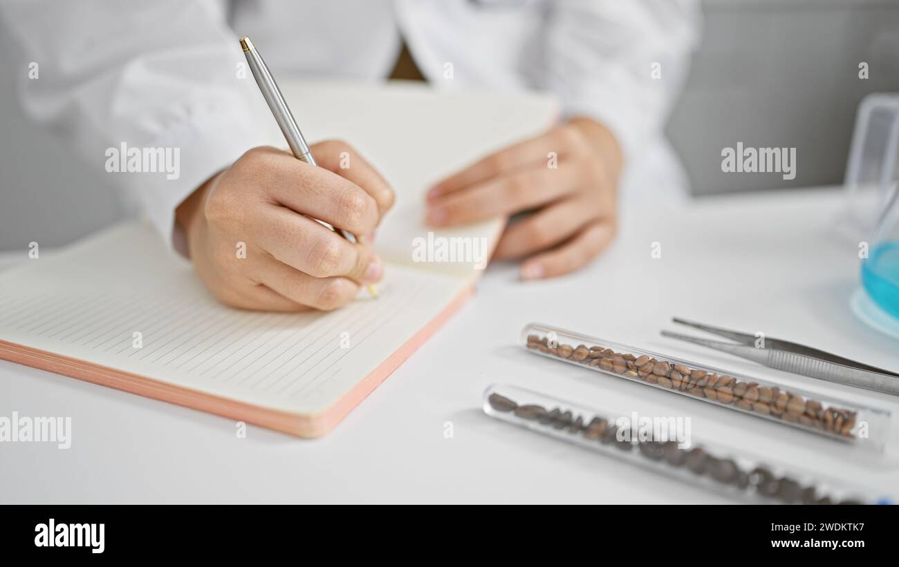 Dedicated hispanic woman scientist engrossed in study, scribbling notes ...