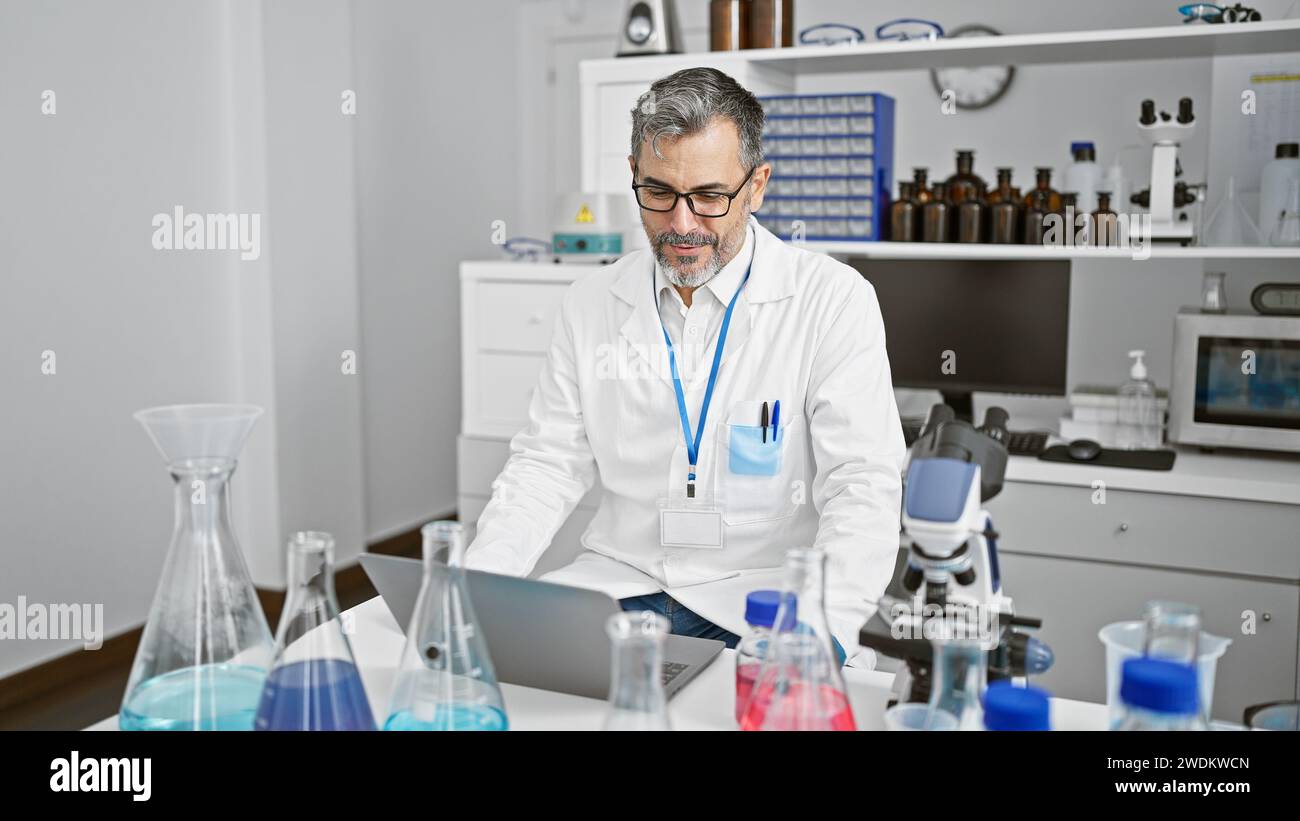 Handsome young hispanic grey-haired scientist engaged in important medical research, making ...