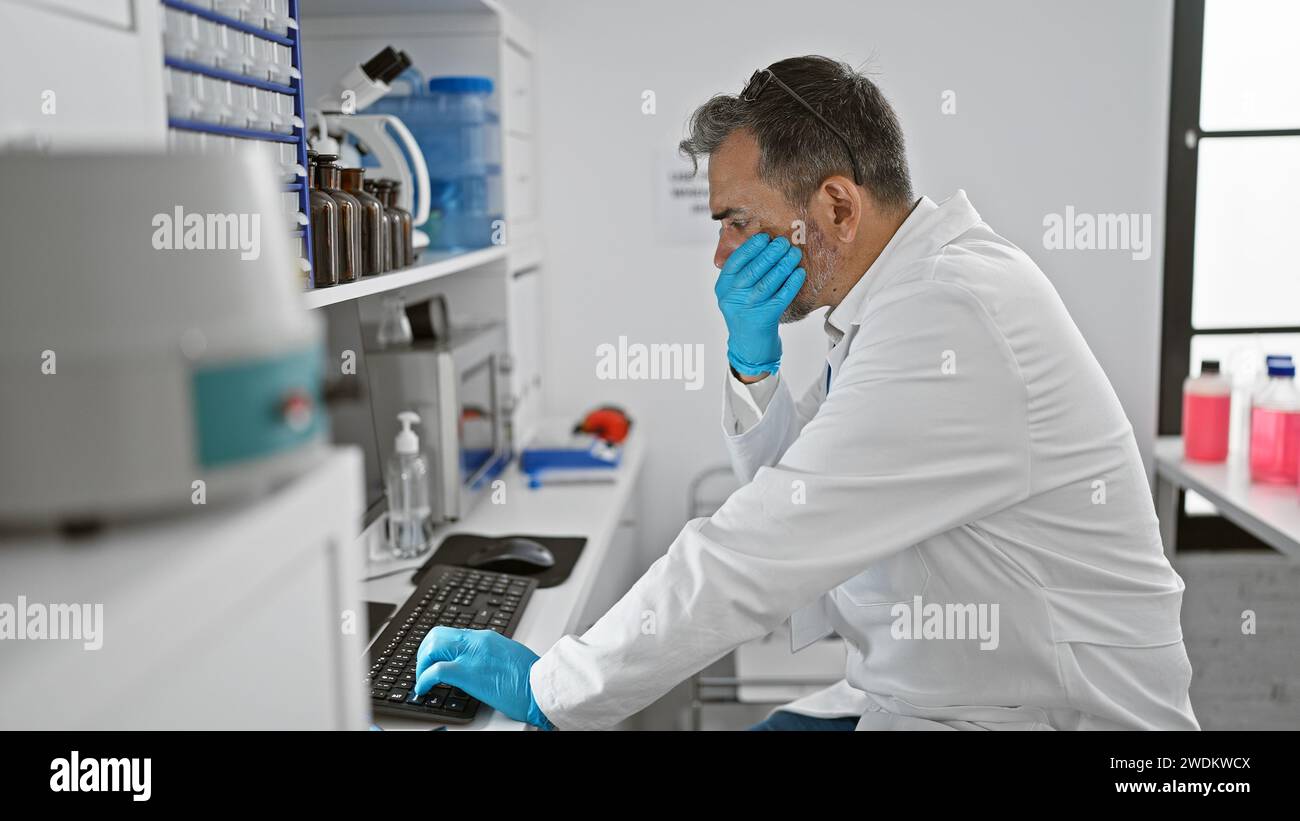 Concentrated young, grey-haired hispanic man, a dedicated scientist ...