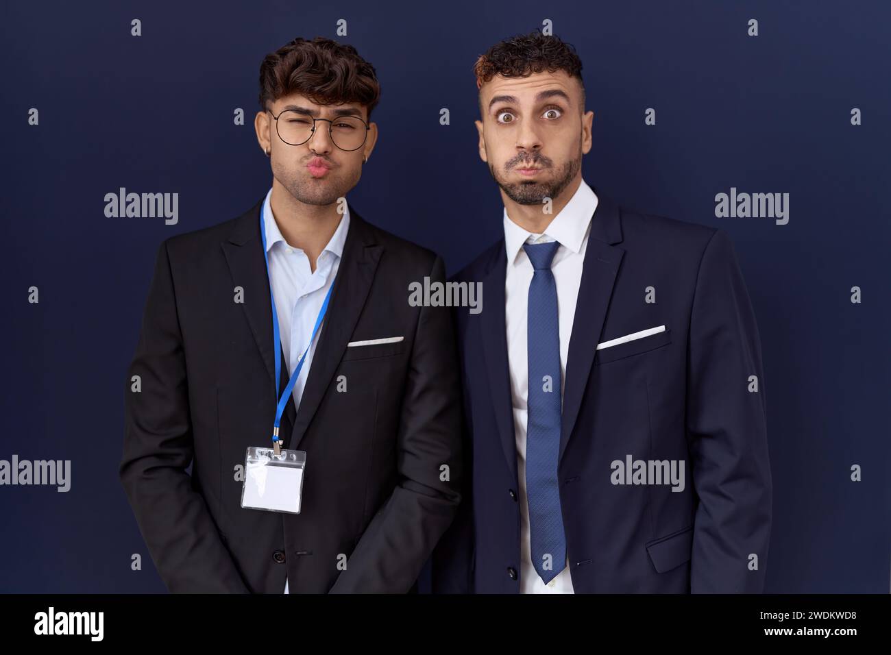 Two hispanic business men wearing business clothes puffing cheeks with ...