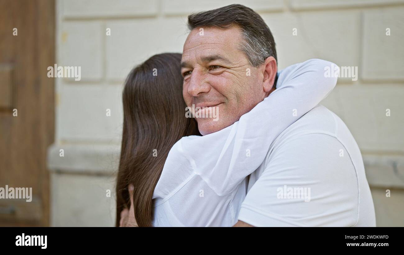 Confident father shares a hearty, smiling hug with his daughter on a ...