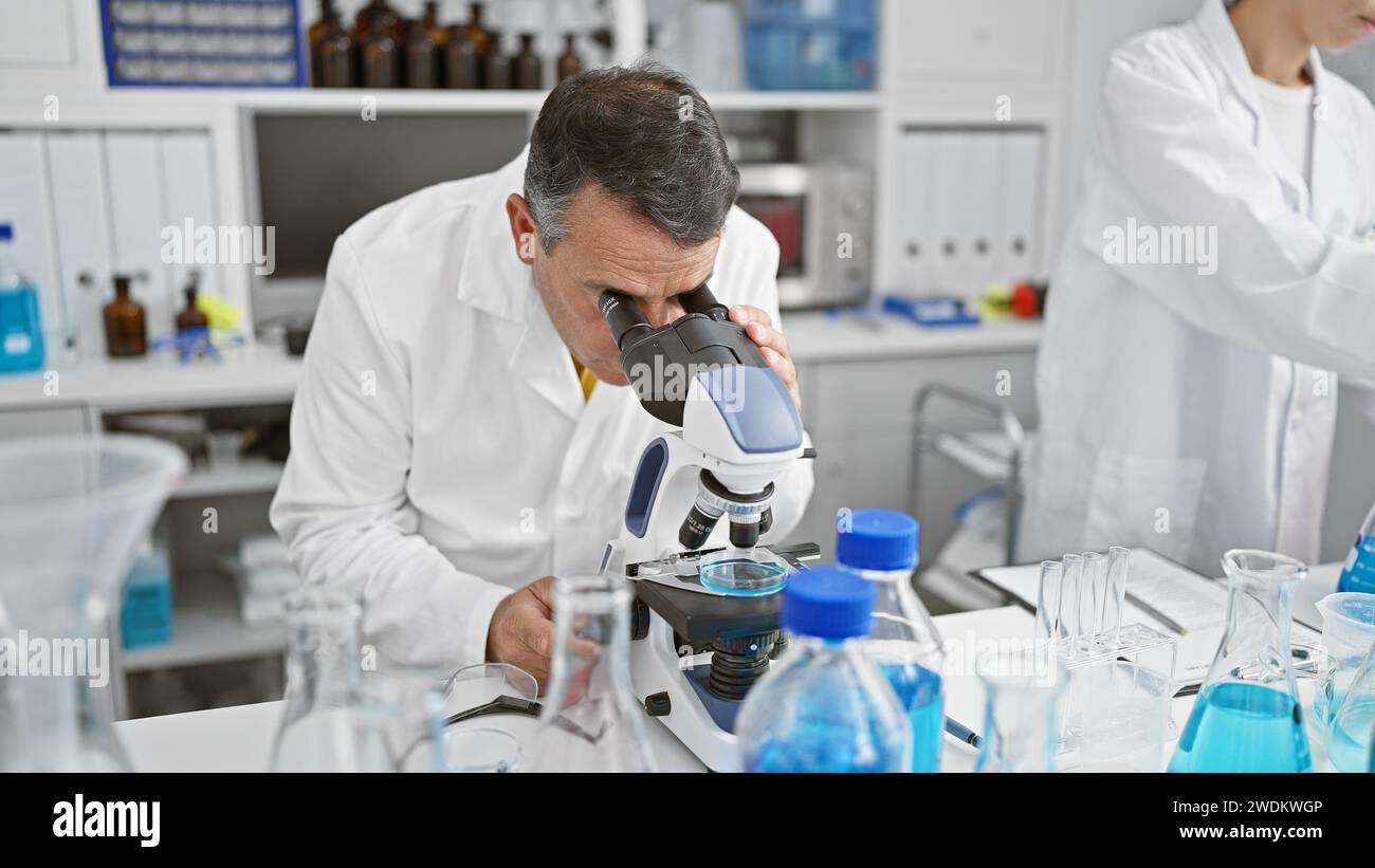 Hispanic man and woman as focused science partners, seriously working ...