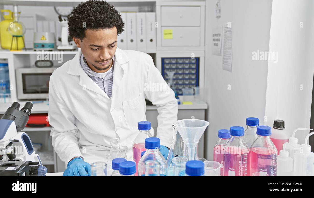 African adult man scientist conducting research in a chemistry ...