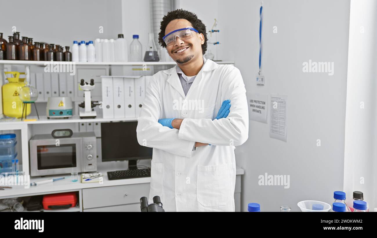 Confident male scientist with curly hair smiling in a laboratory ...
