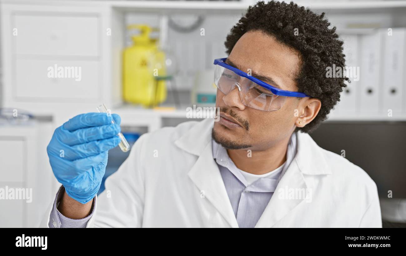 Focused man analyzing a sample in a modern laboratory setting wearing ...