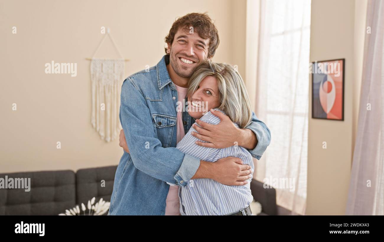 Confident mother and son share a warm, smiling hug indoors, enjoying ...