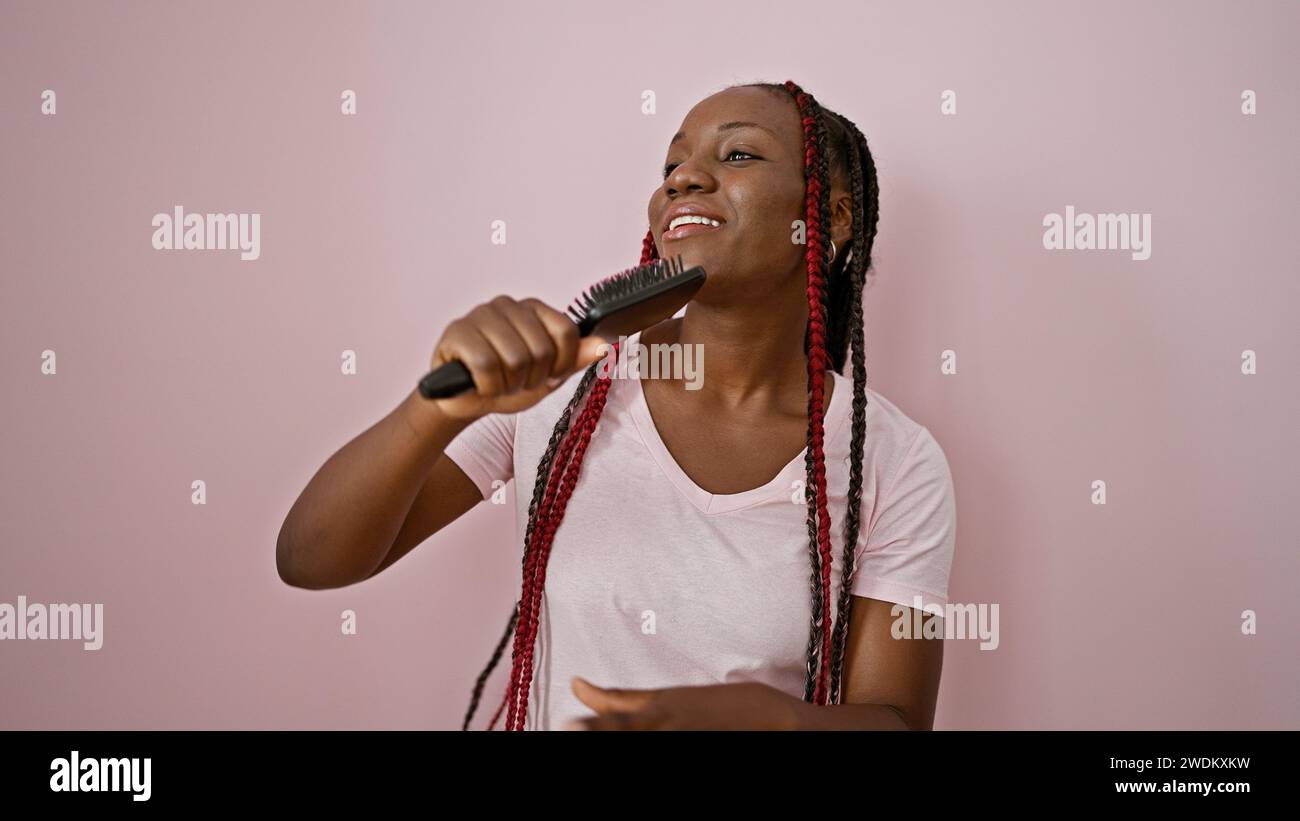Confident african american woman joyfully singing song using brush as ...