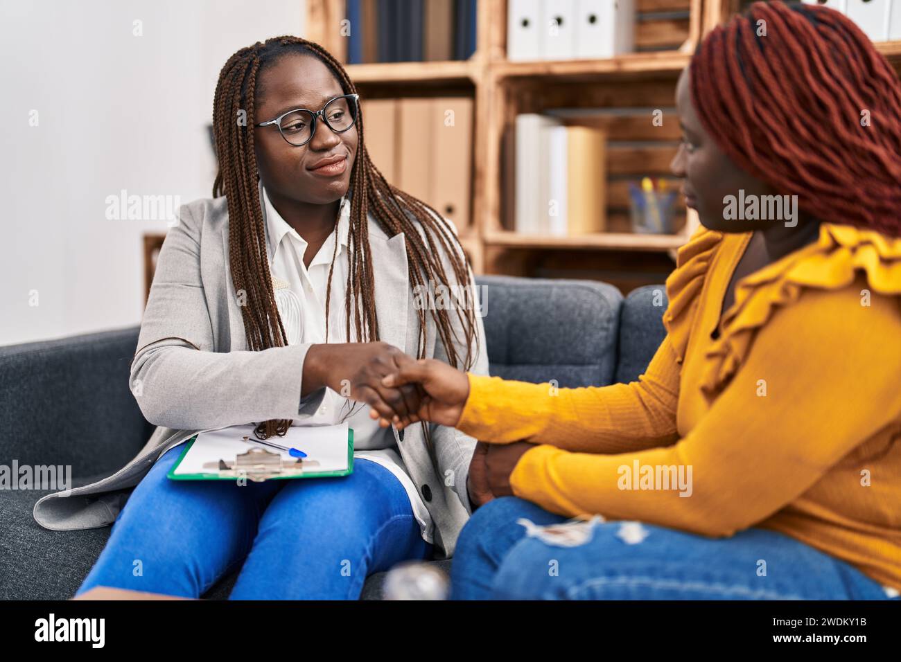 African american women psychologist and patient smiling confident shake ...