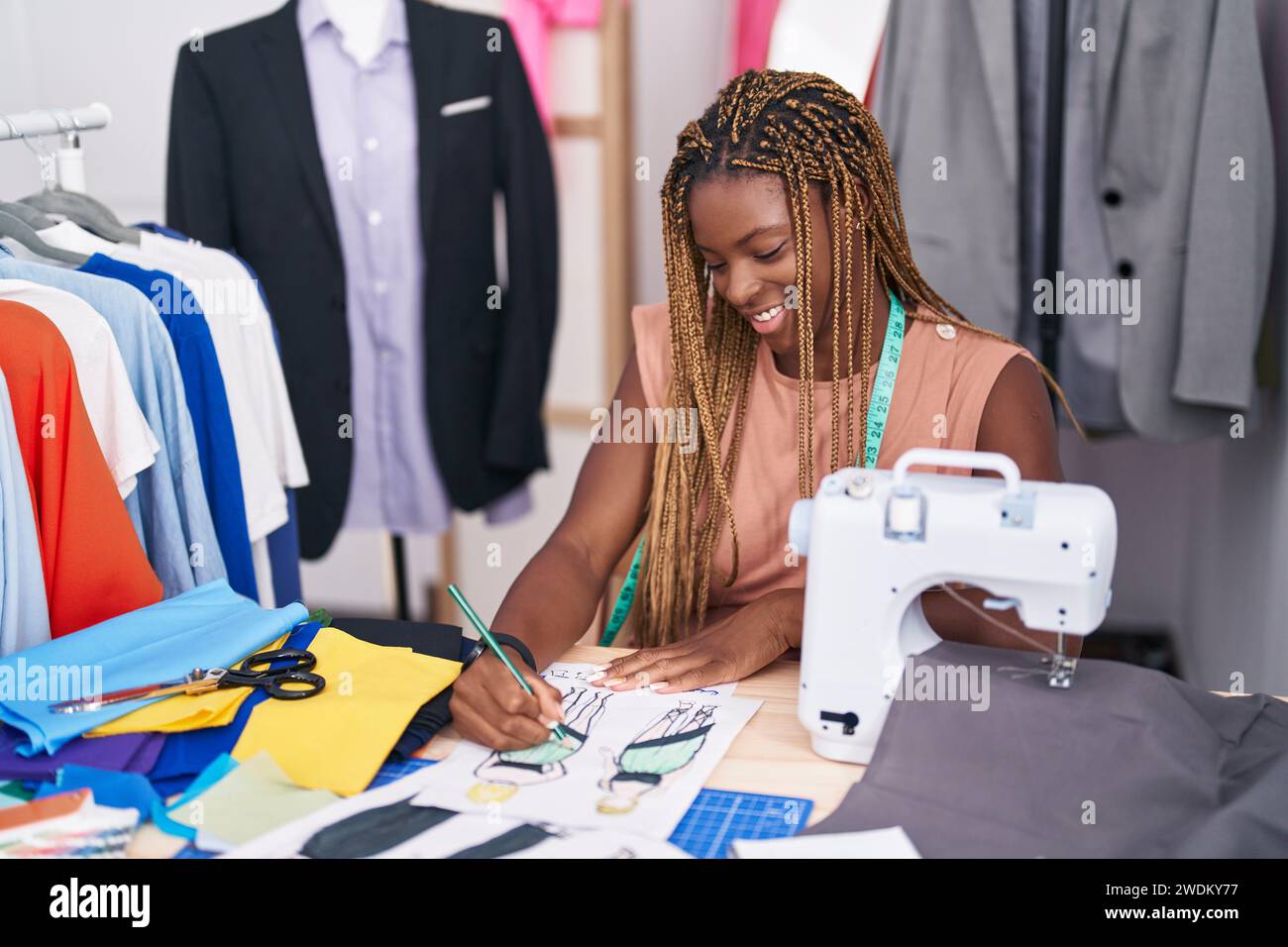 African american woman tailor smiling confident drawing clothing design ...