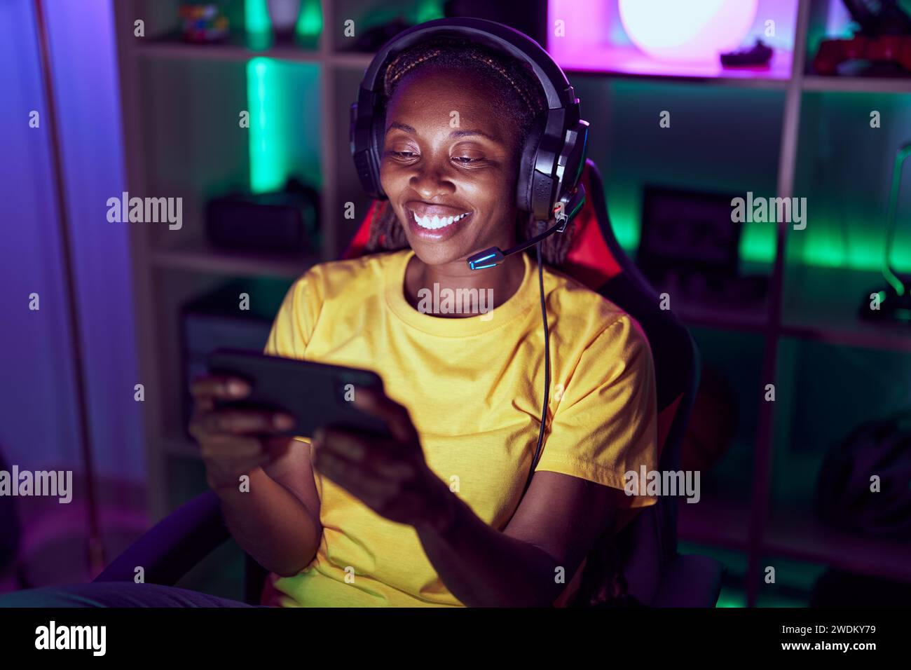African american woman streamer playing video game using smartphone at ...