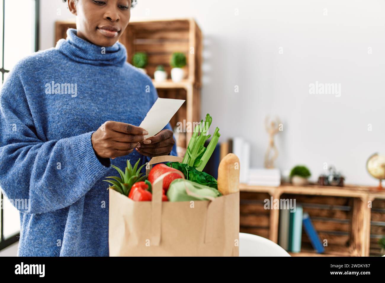 African american woman reading food receipt at home Stock Photo - Alamy