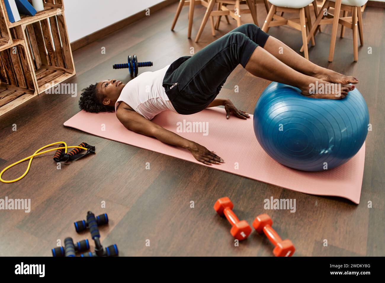 African american woman training abs exercise using fit ball at home ...
