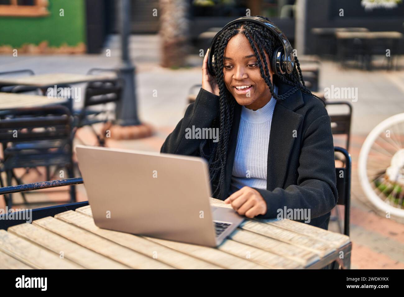 African american woman having video call sitting on table at coffee ...