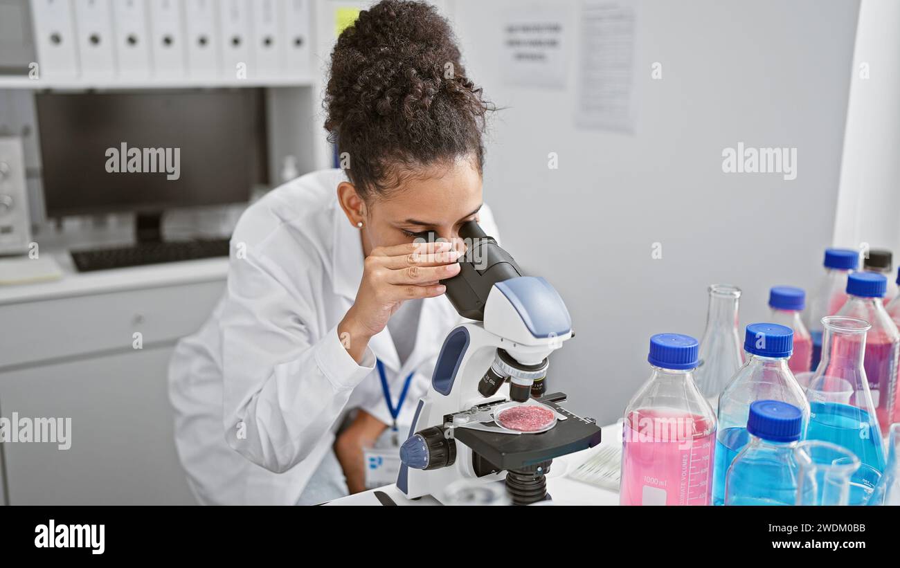 In the heart of a lab, a young, beautiful hispanic woman scientist ...