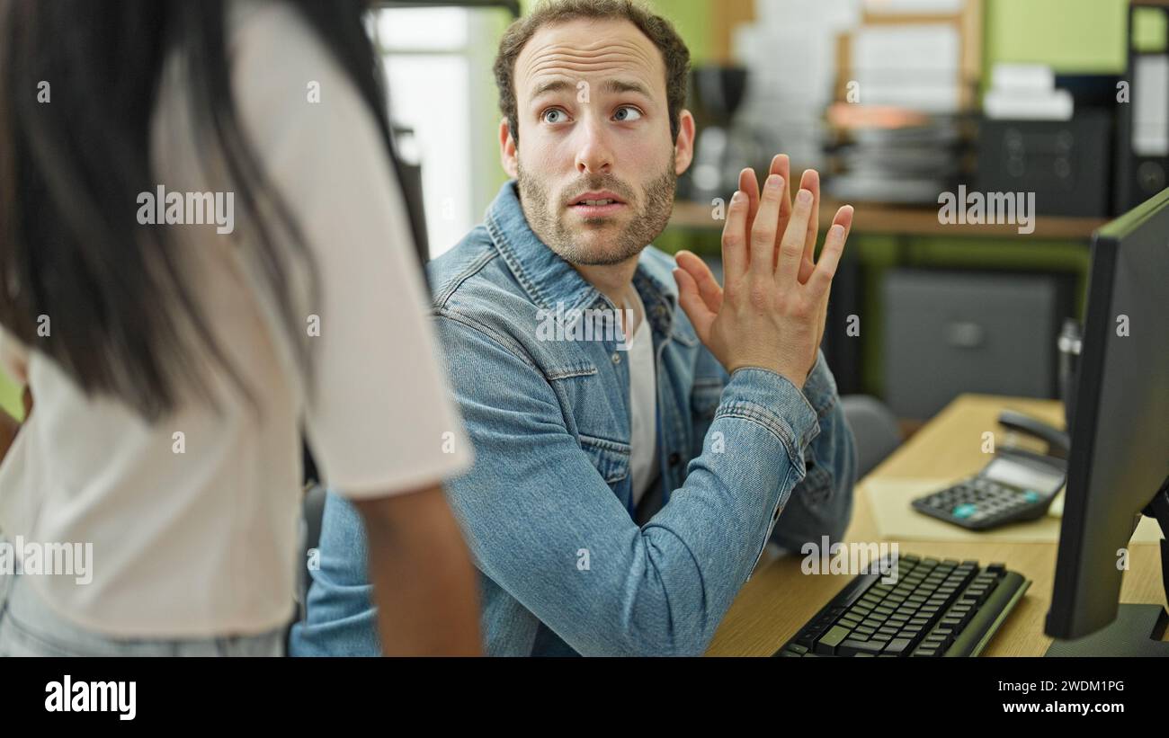 Two workers man and woman using computer speaking at the office Stock ...