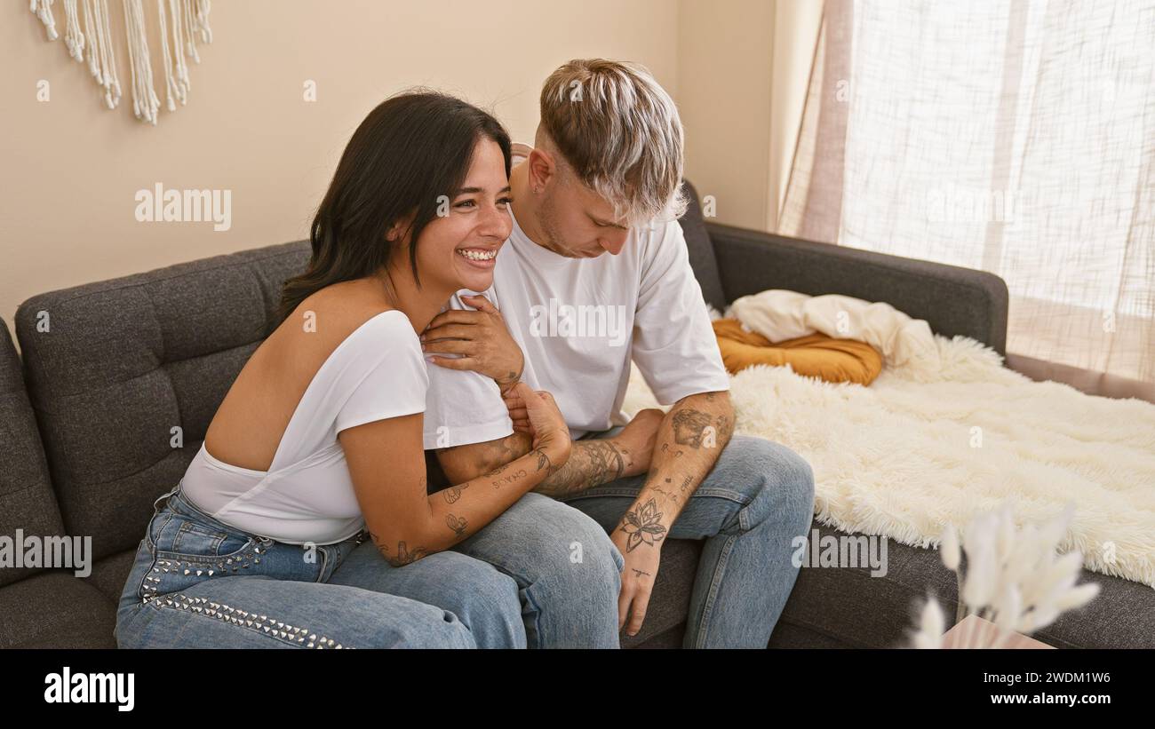 Happy couple embracing on a couch in a cozy living room, showing ...