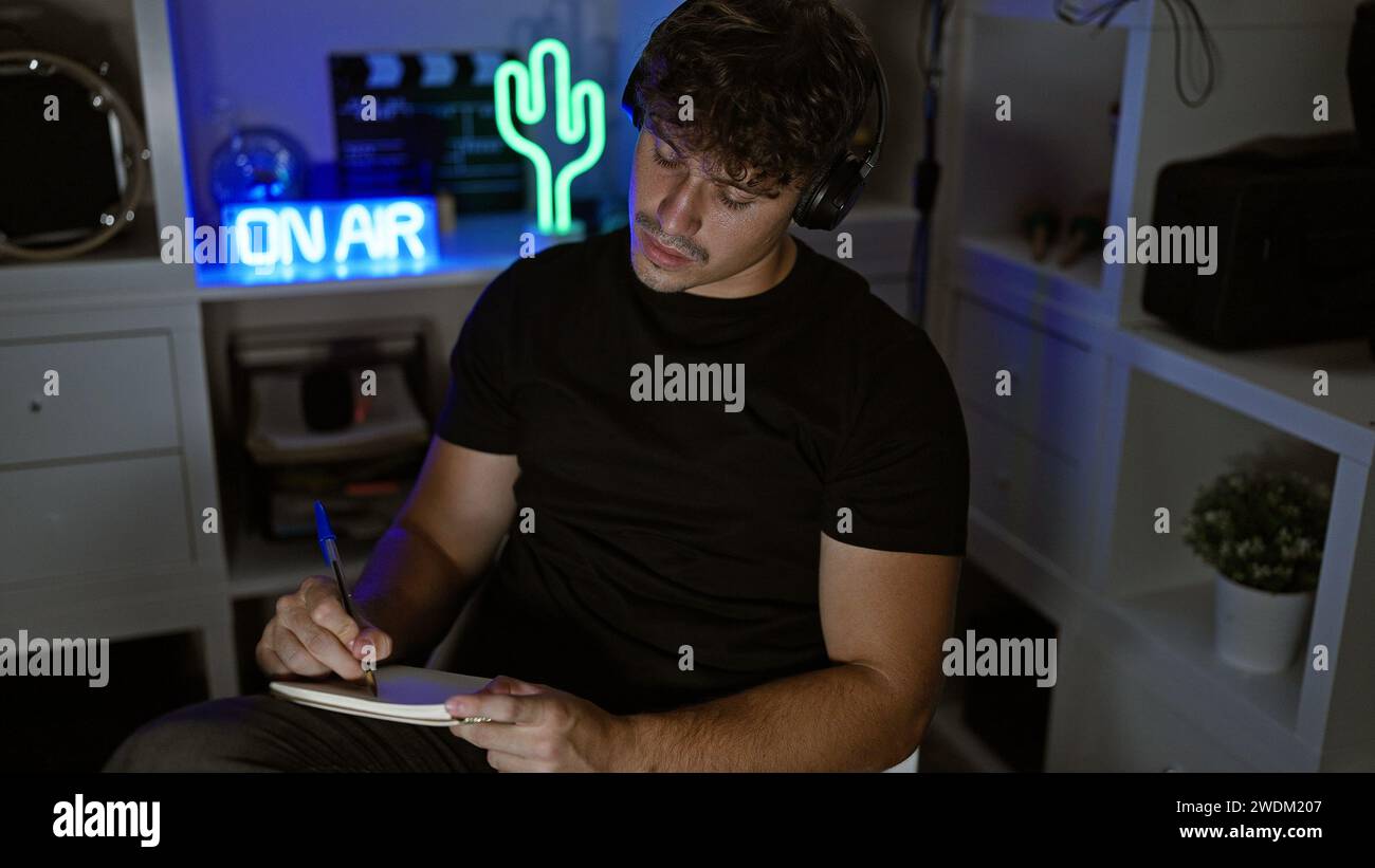 Young hispanic man streamer sitting on table taking notes at gaming ...