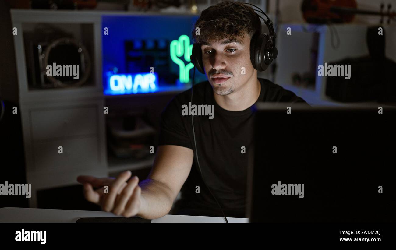 Handsome young hispanic man, a streamer in his gaming room, engaging in ...