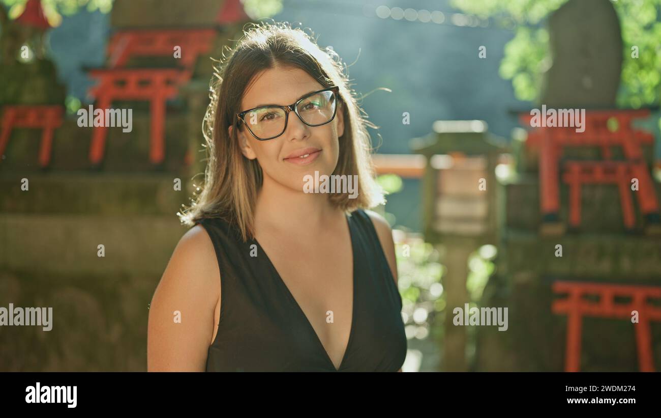 Beautiful hispanic woman with glasses poses at fushimi inari-taisha ...